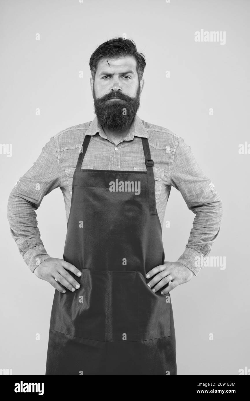 Bearded man in cook uniform. Mature shop assistant. Chef in red apron ...