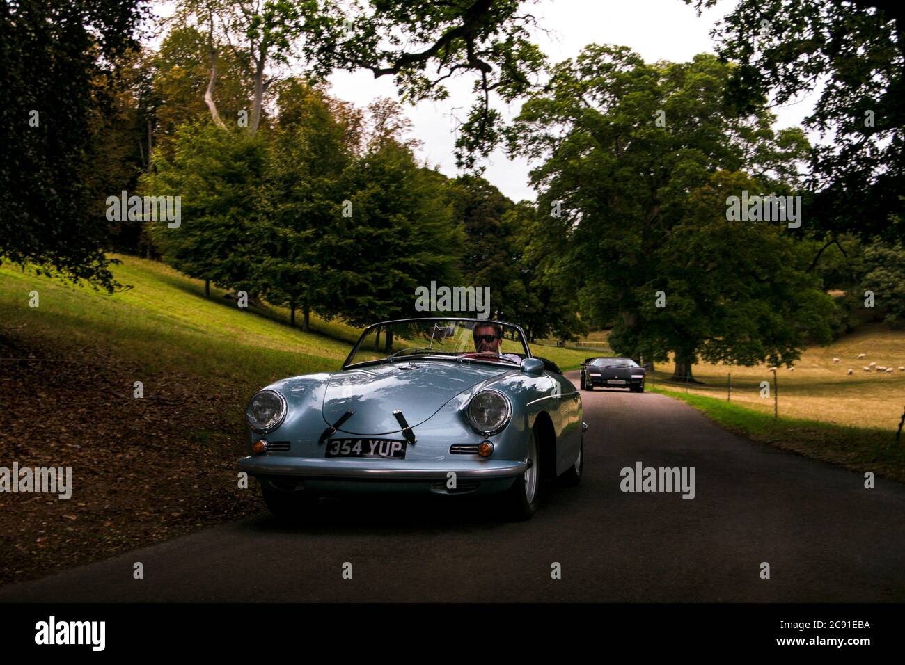 Light blue Porsche 356 classic sports car, followed by a black ...