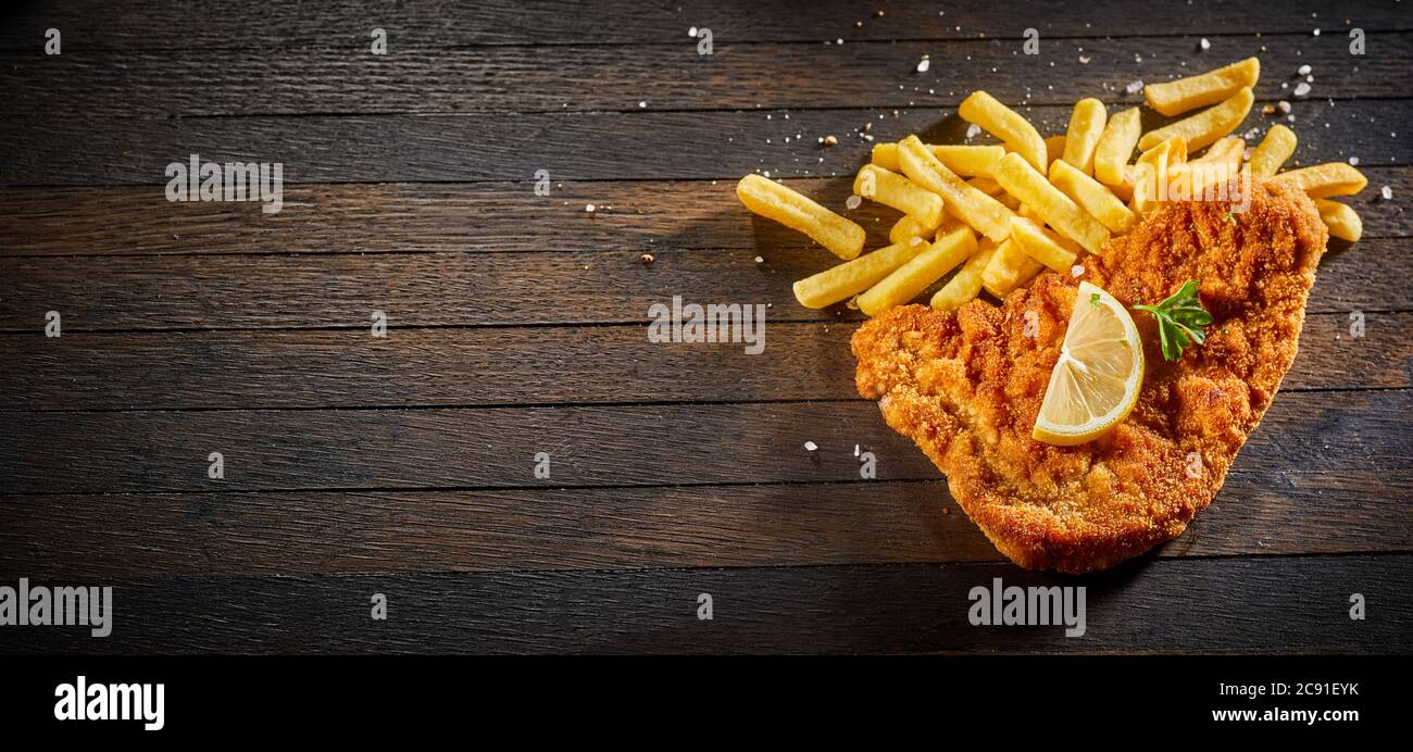 Schnitzel with French fries seasoned with salt and spices and served ...