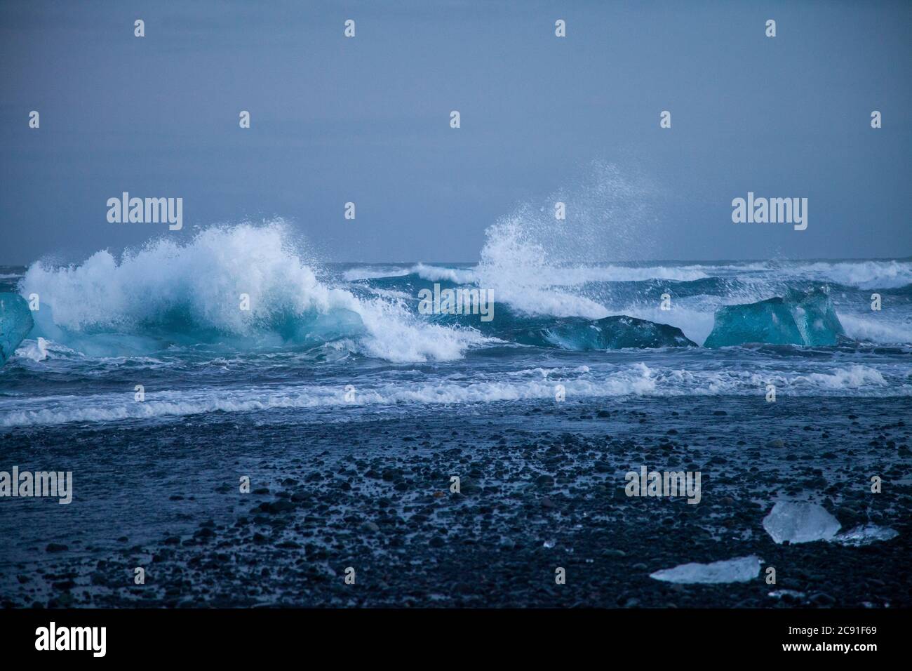 A famous beach in Iceland with a lot pieces of ice on the sand that ...