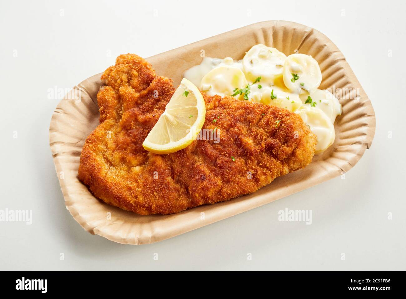 Portion of fried battered fish or German schnitzel with salad for ...