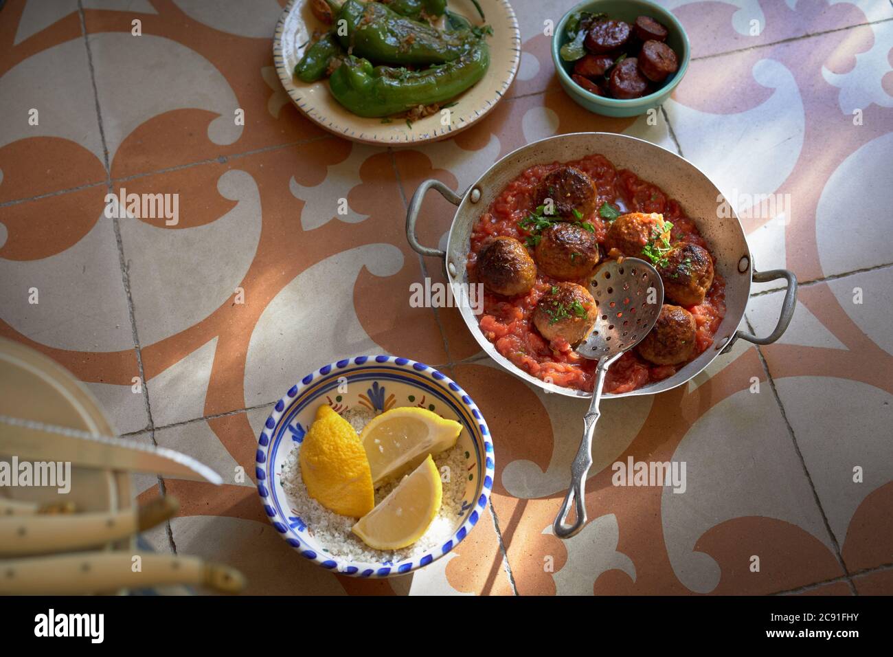 Assorted Spanish tapas with roasted green peppers and meatballs in a ...
