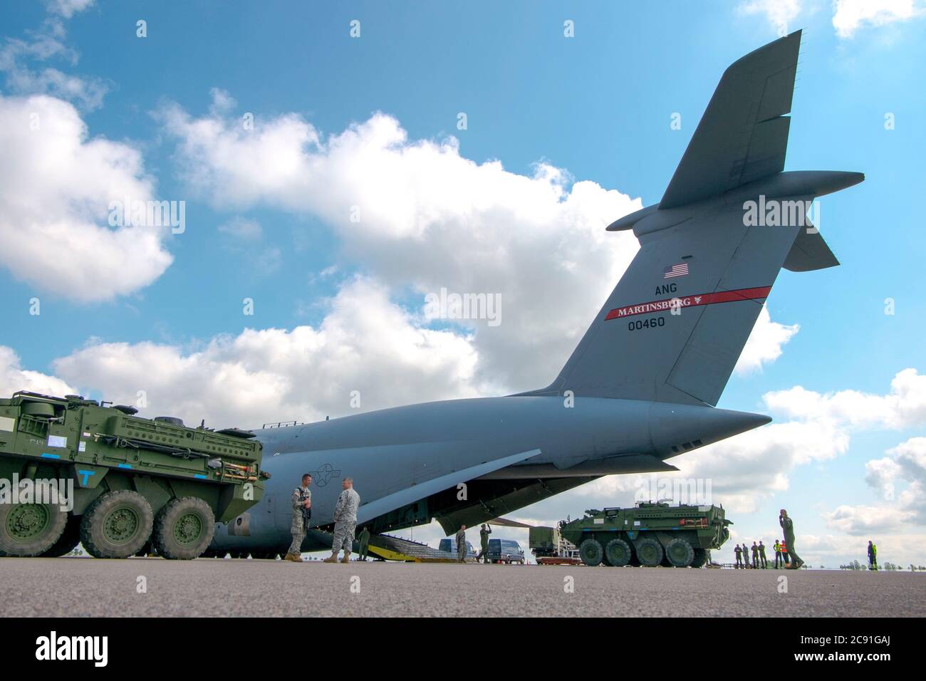 A group of Strykers are unloaded from a jumbo C-5 Air Force plane flown ...