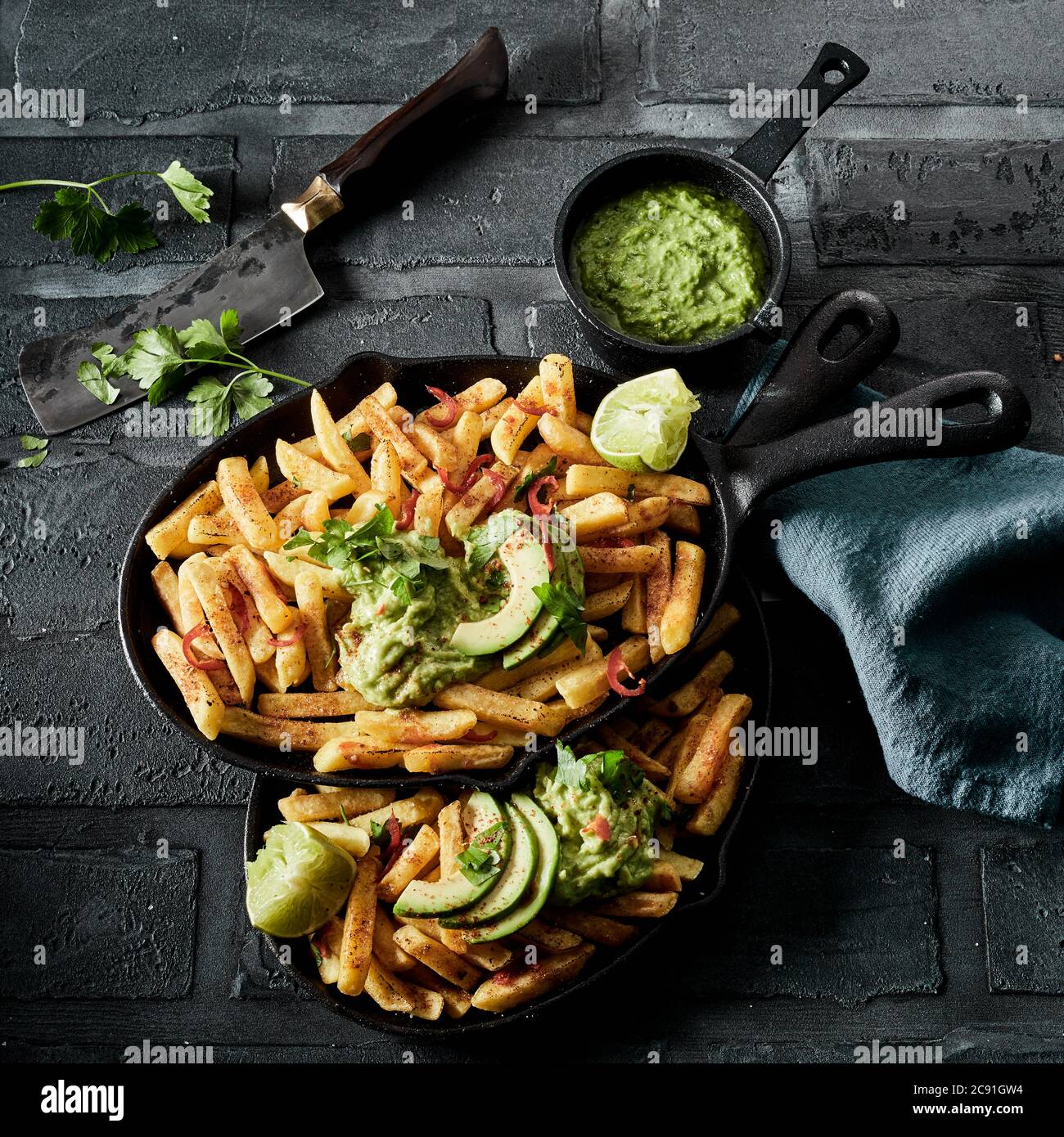 Two skillets with servings of oven-baked French fries and Mexican ...