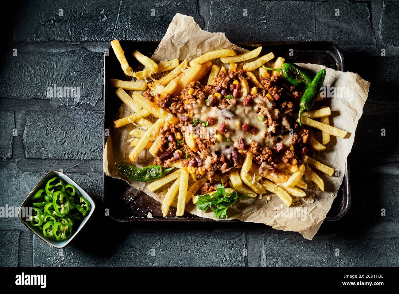 Serving of potato fries with a topping of cheese and mince meat ...
