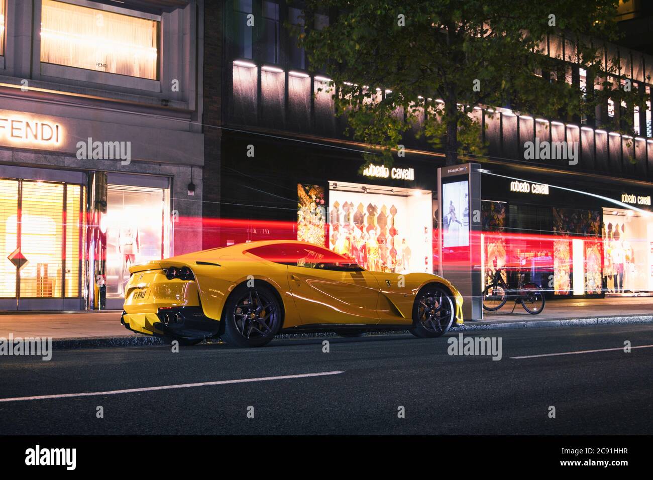 Yellow Ferrari 812 Superfast photographed at night on a street in ...