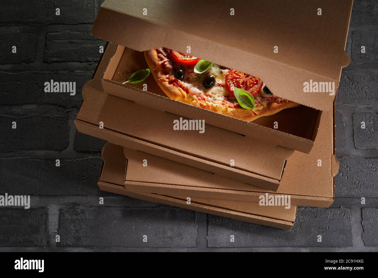 Italian pizza packed ready to go in a brown cardboard takeout box on ...