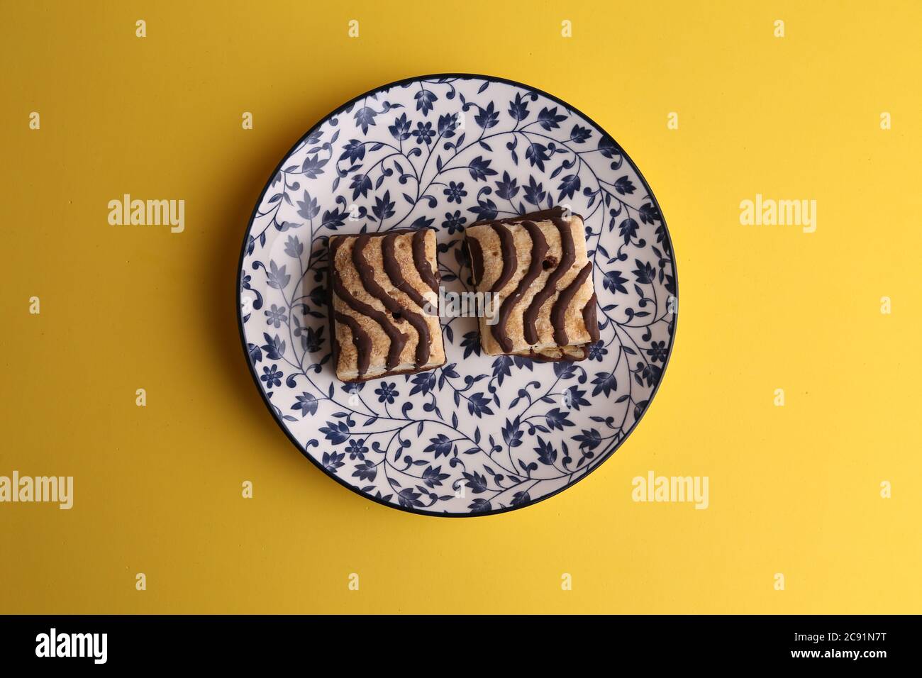 Overhead shot of delicious square biscuits with chocolate cream on a ...