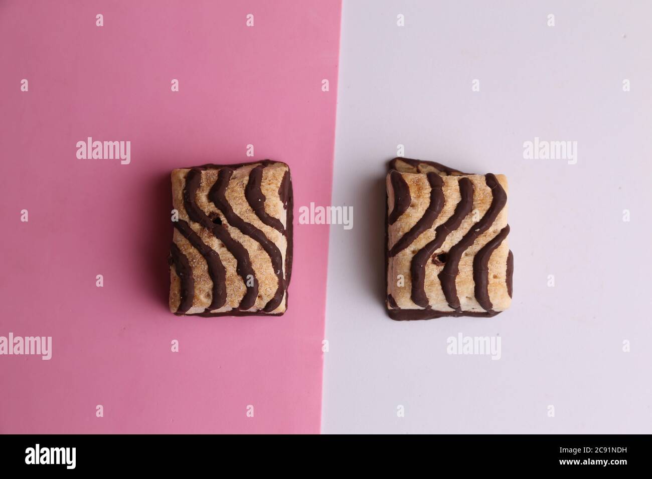 Top view of two chocolate biscuits isolated on a pink and white ...