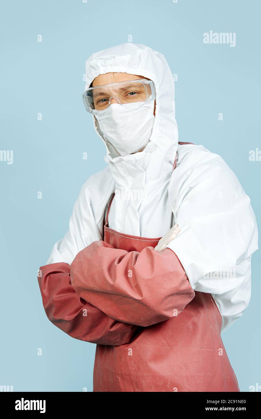 Surgeon in white costume covering all skin, wearing red apron and ...