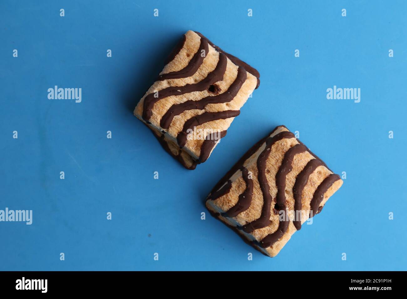 Overhead shot of delicious square biscuits with chocolate cream on a ...