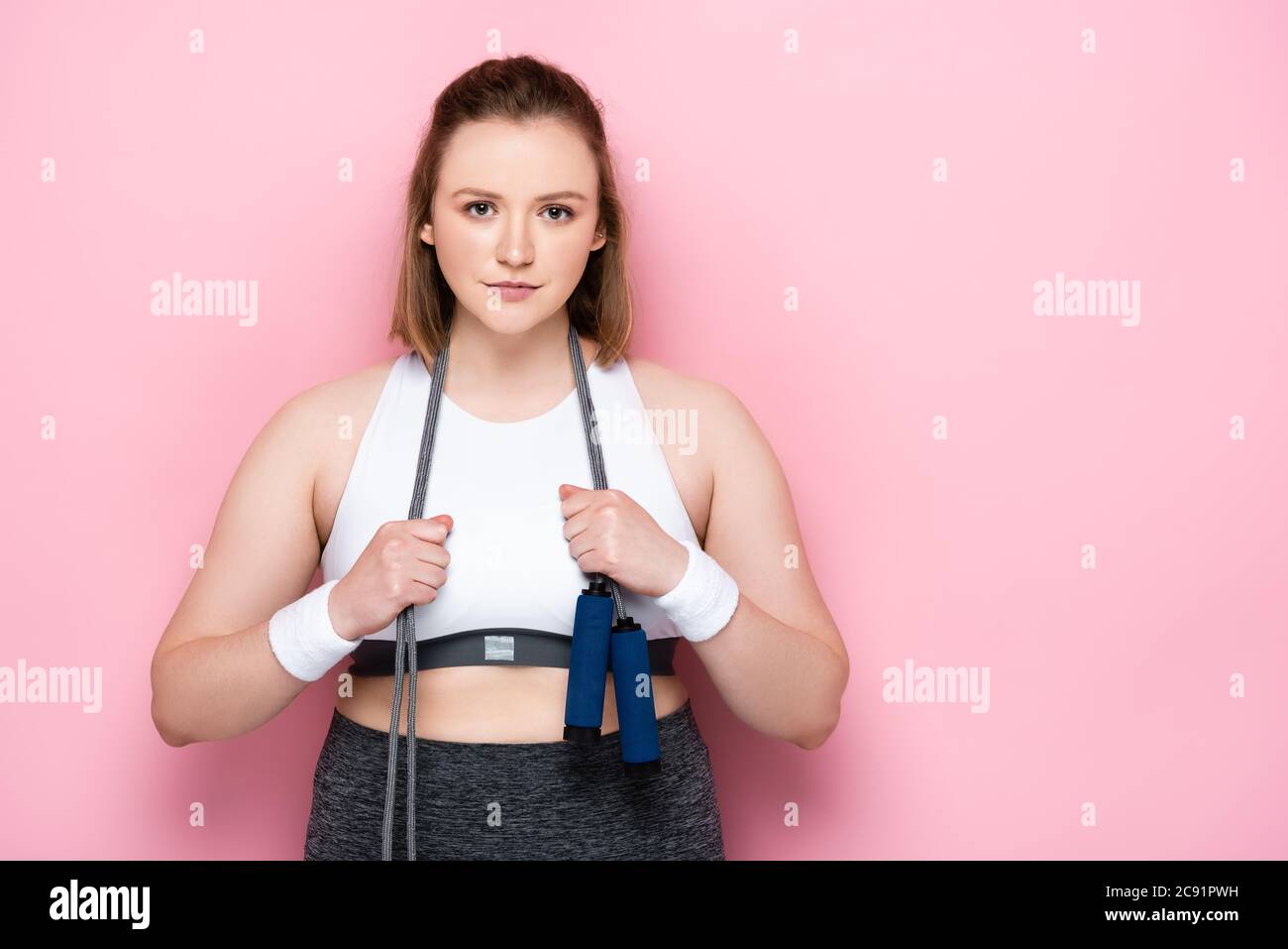 confident overweight girl with jumping rope around neck smiling at ...