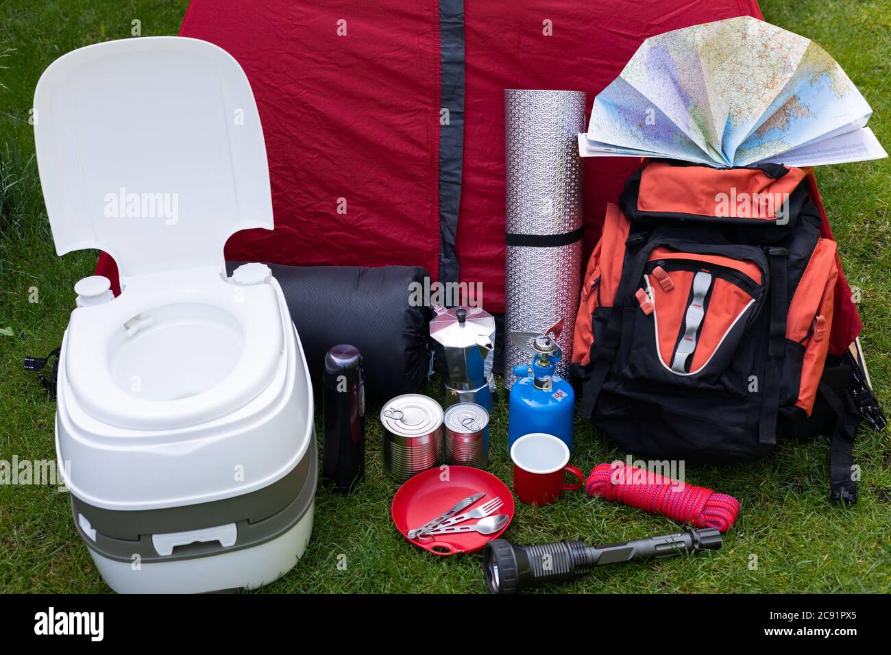 Picture of camping tools on the grass - backpack, tent, gas tank, cans ...
