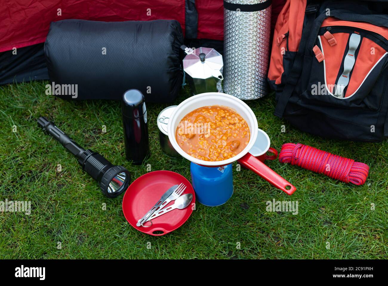 Picture of camping tools on the grass - backpack, tent, gas tank, cans ...