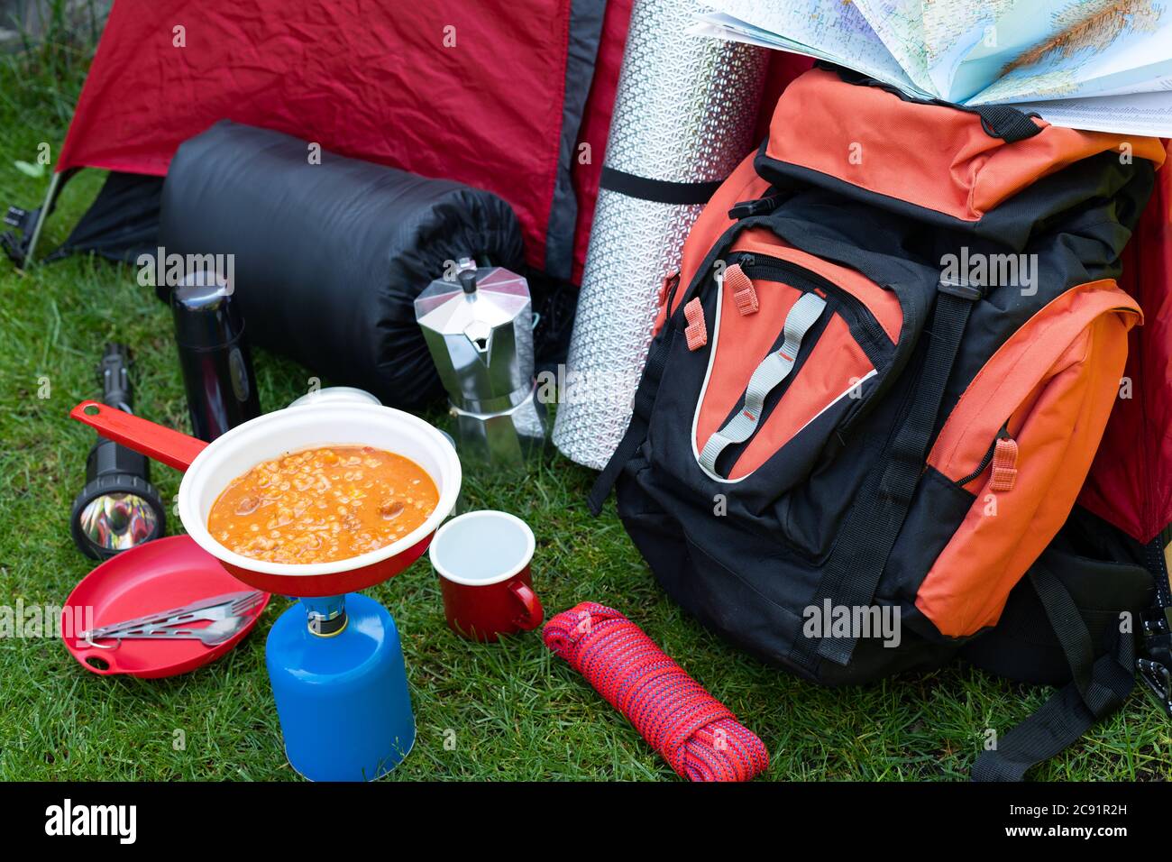 Picture of camping tools on the grass - backpack, tent, gas tank, cans ...