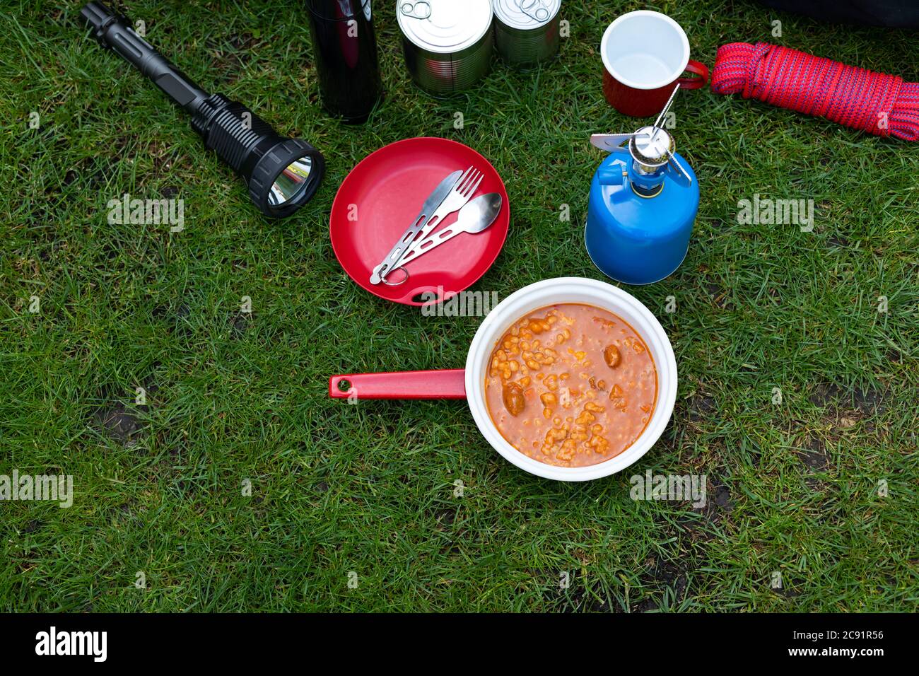 Picture of camping tools on the grass - backpack, tent, gas tank, cans ...