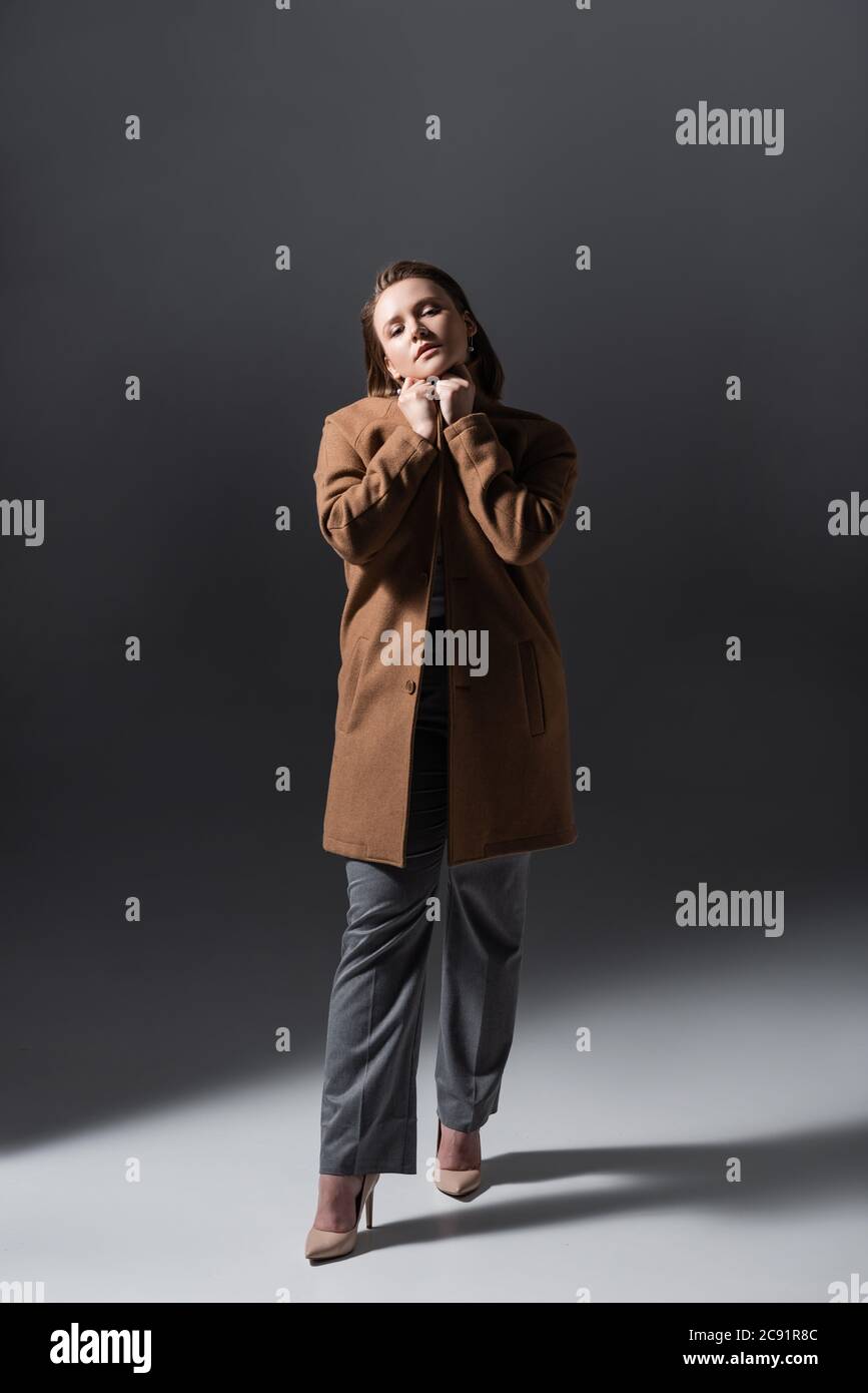 full length view of attractive plus size girl holding hands near face ...