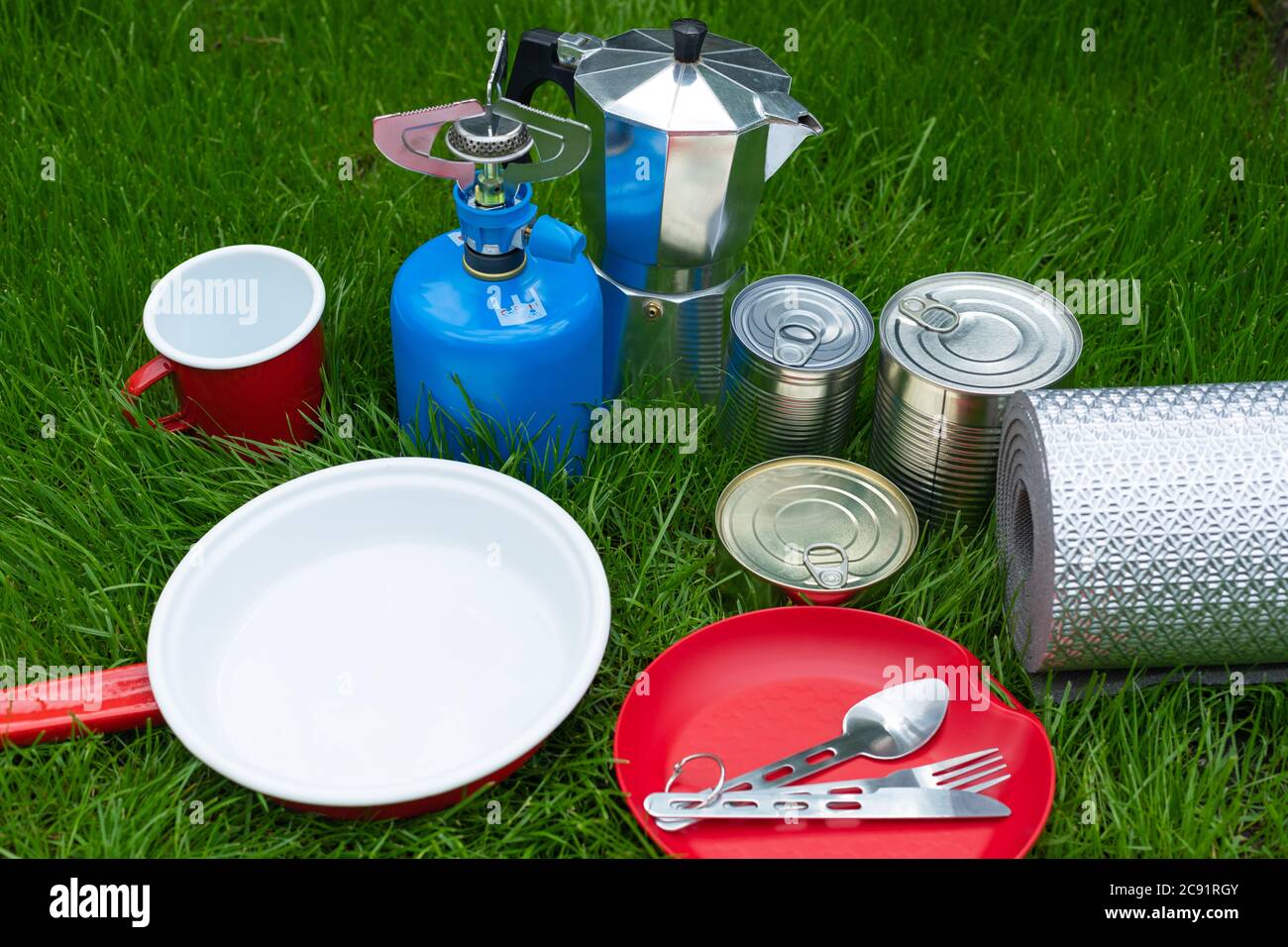 Picture of camping tools on the grass - backpack, tent, gas tank, cans ...