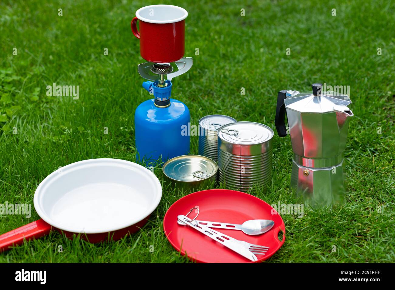 Picture of camping tools on the grass - backpack, tent, gas tank, cans ...
