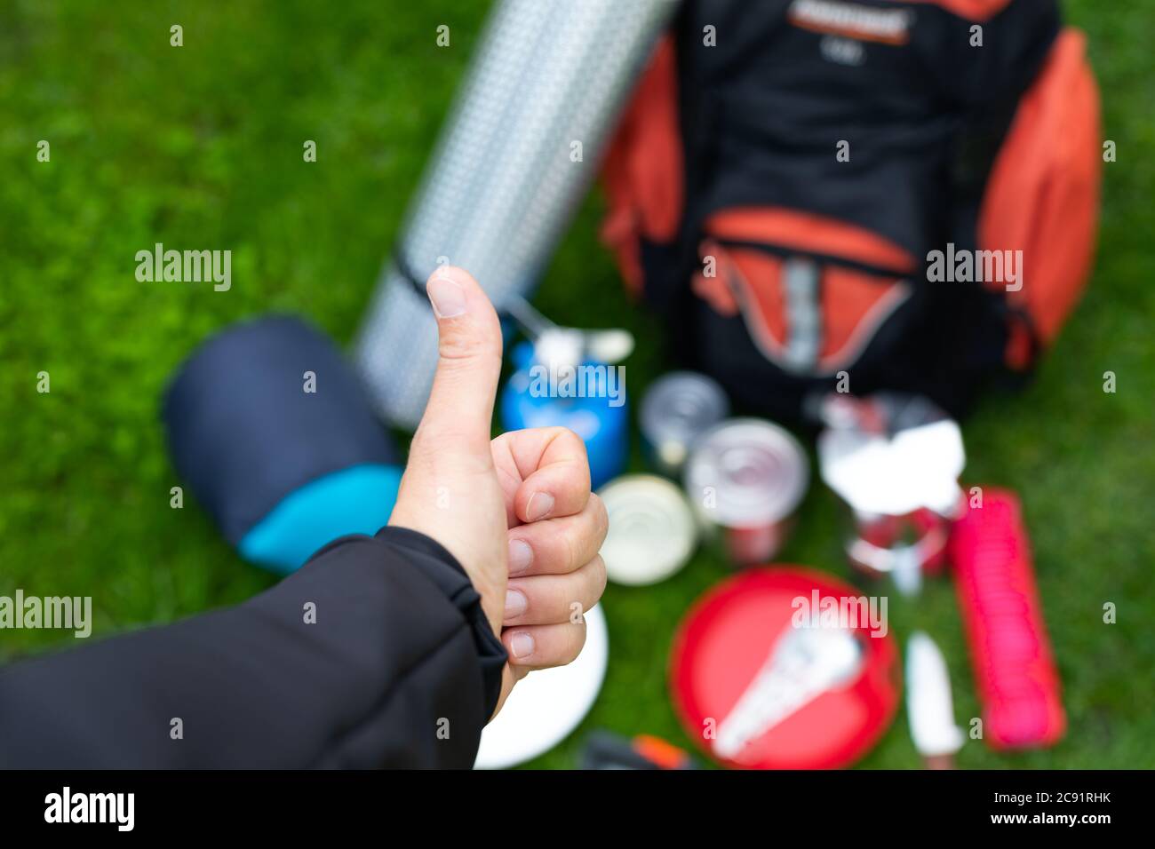 Picture of camping tools on the grass - backpack, tent, gas tank, cans ...