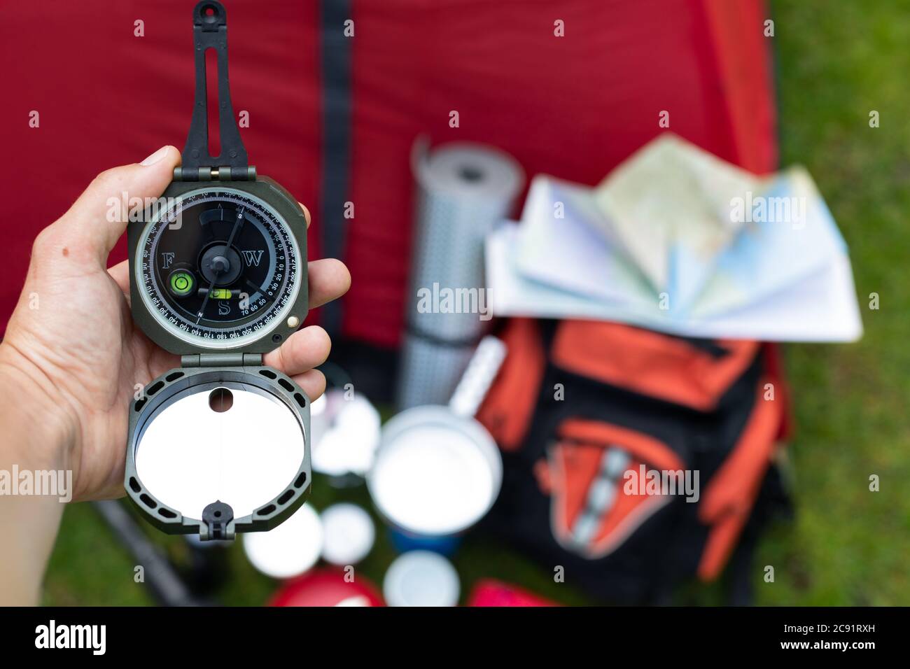 Picture of camping tools on the grass - backpack, tent, gas tank, cans ...