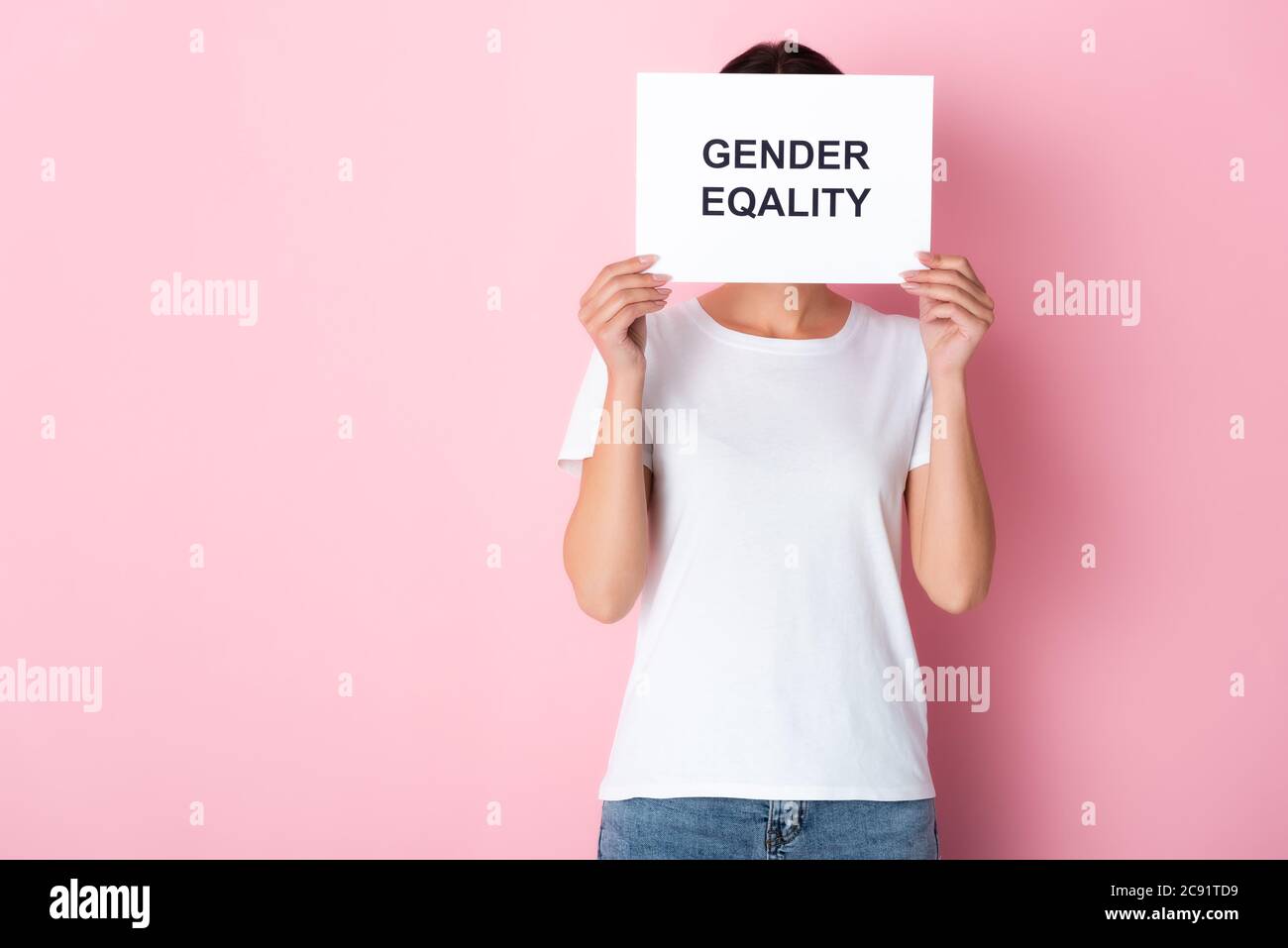woman in white t-shirt covering face with gender equality lettering on ...
