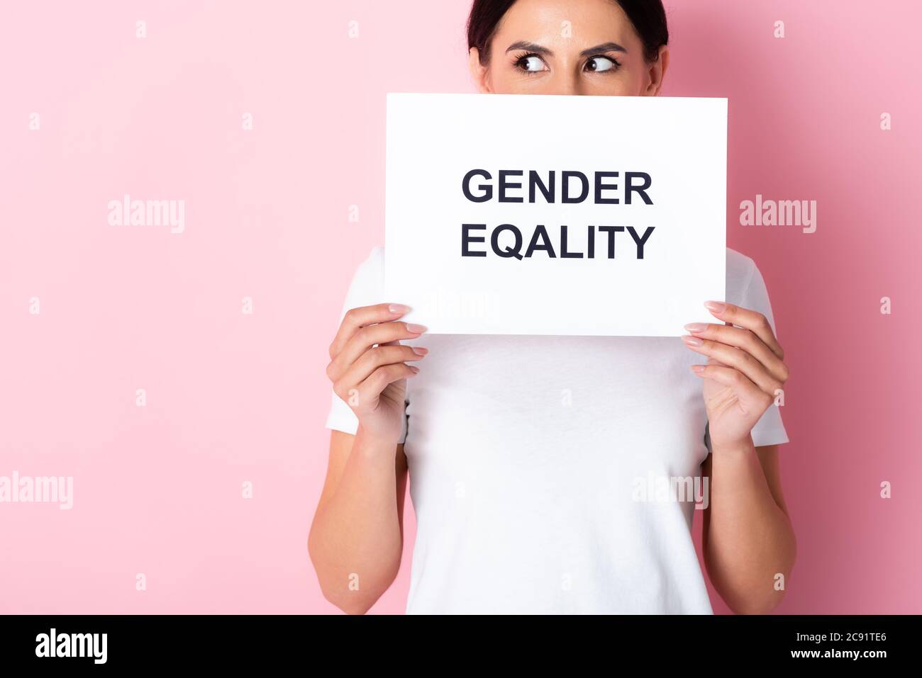 woman in white t-shirt covering face with gender equality lettering on ...