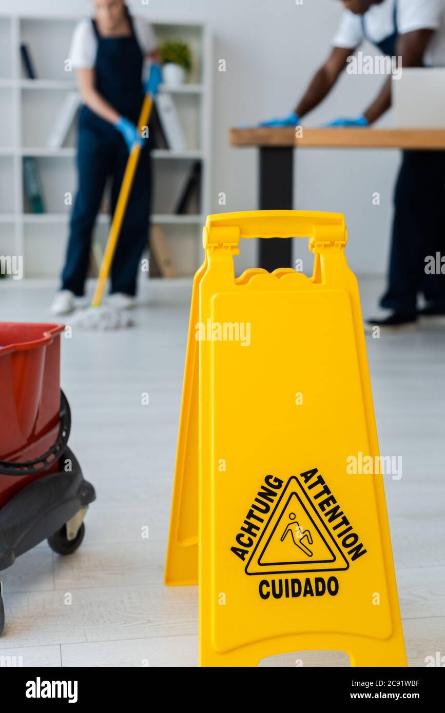 Selective focus of wet floor sign with attention lettering and ...