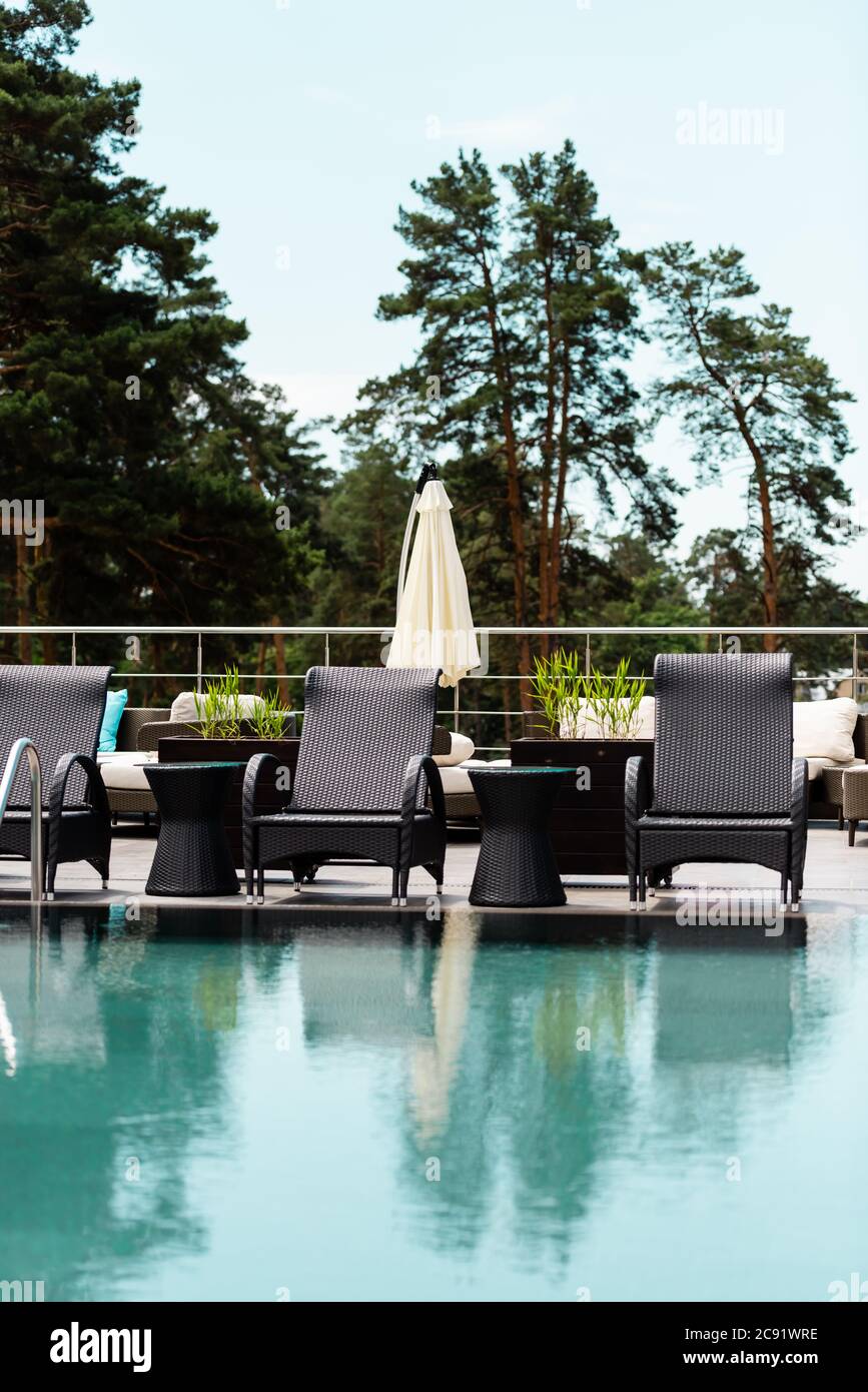 modern sunbeds near swimming pool with blue water Stock Photo - Alamy