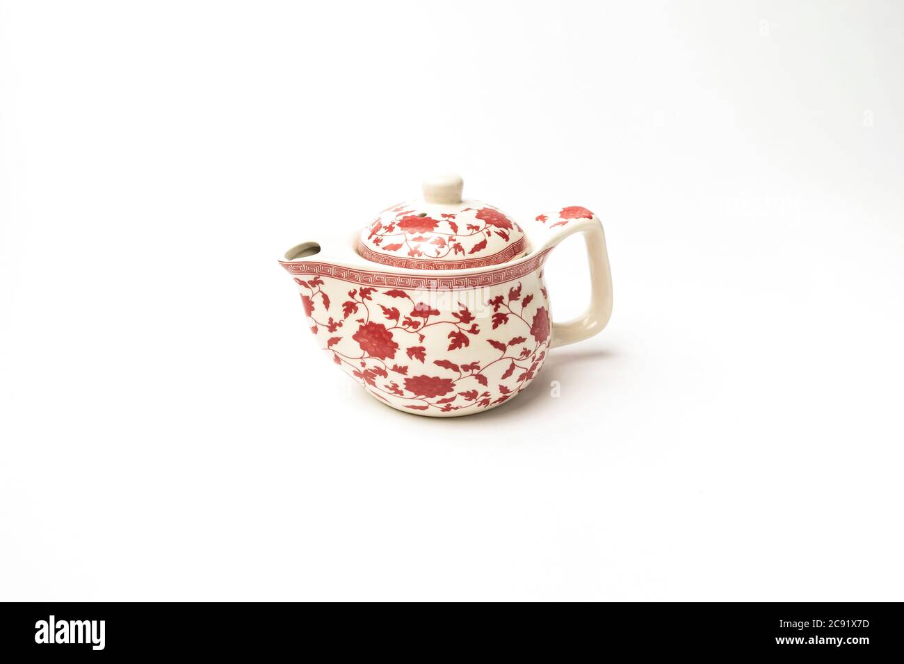 Red and white ceramic teapot with flower patterns isolated on a white ...
