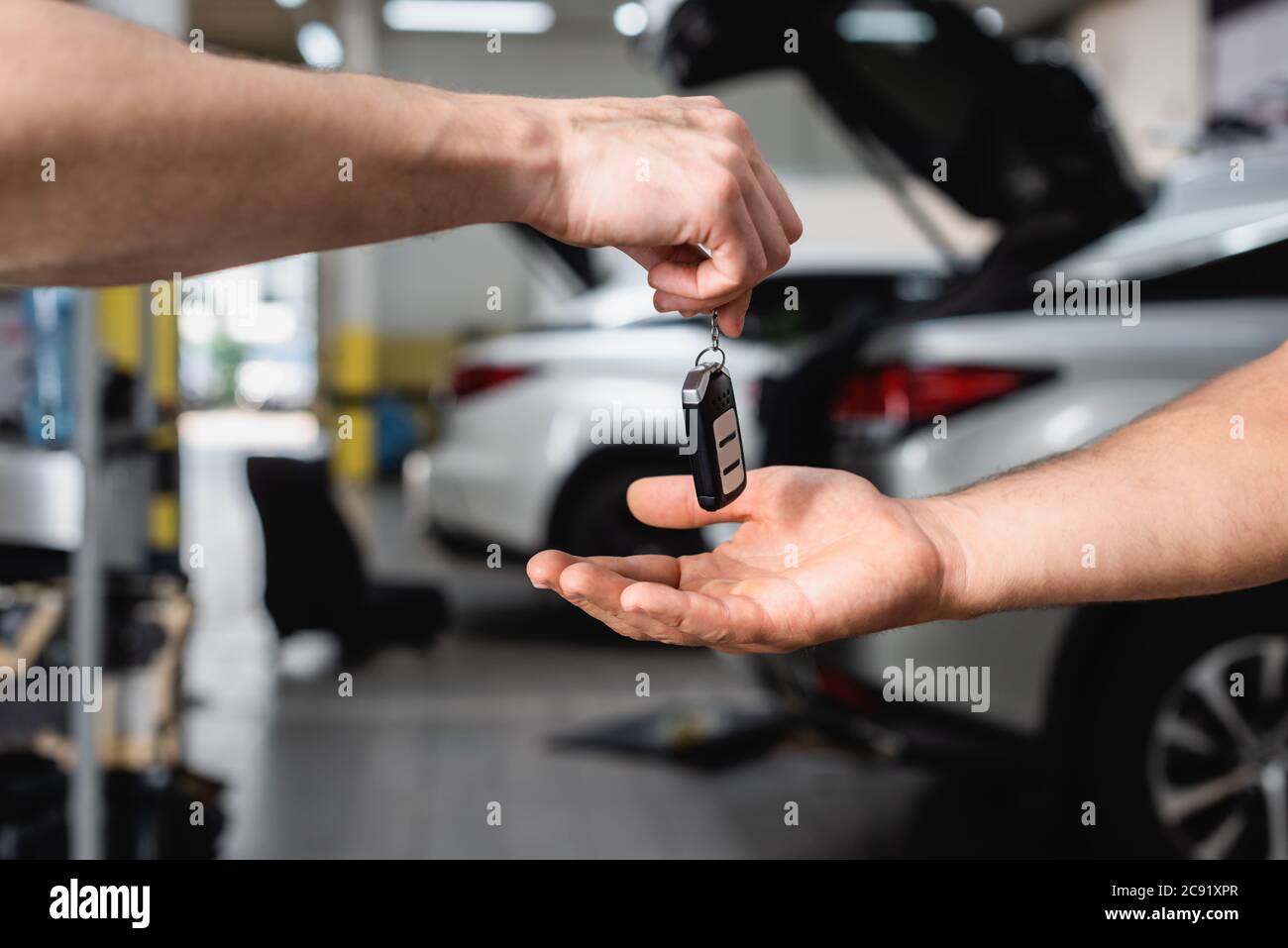 Selective focus of man receiving car key at service station Stock Photo ...
