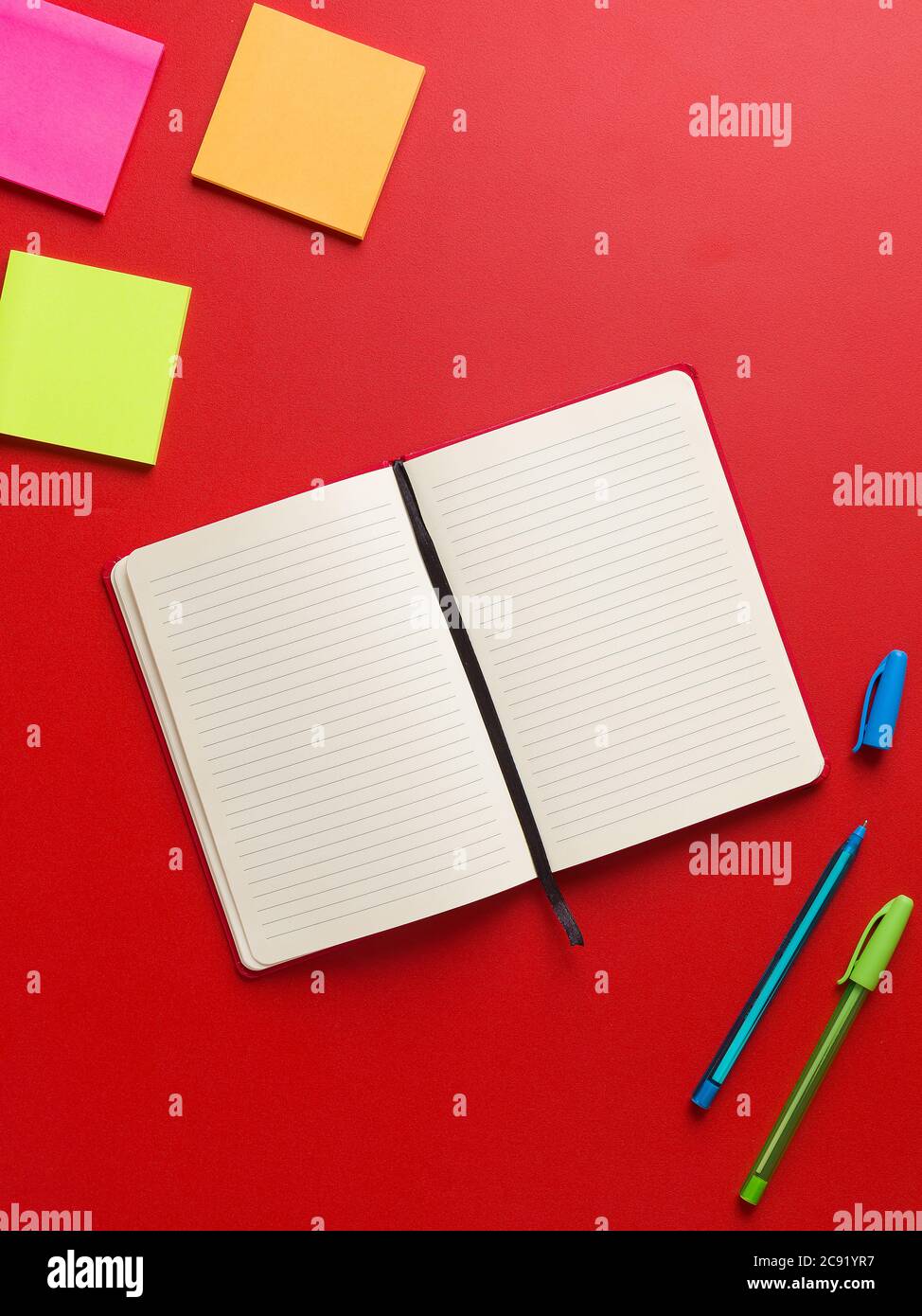 Top view of an open blank red notebook in the center, colored reminders ...