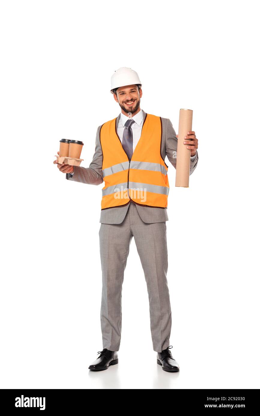 Smiling engineer in suit and safety vest holding paper cups and ...