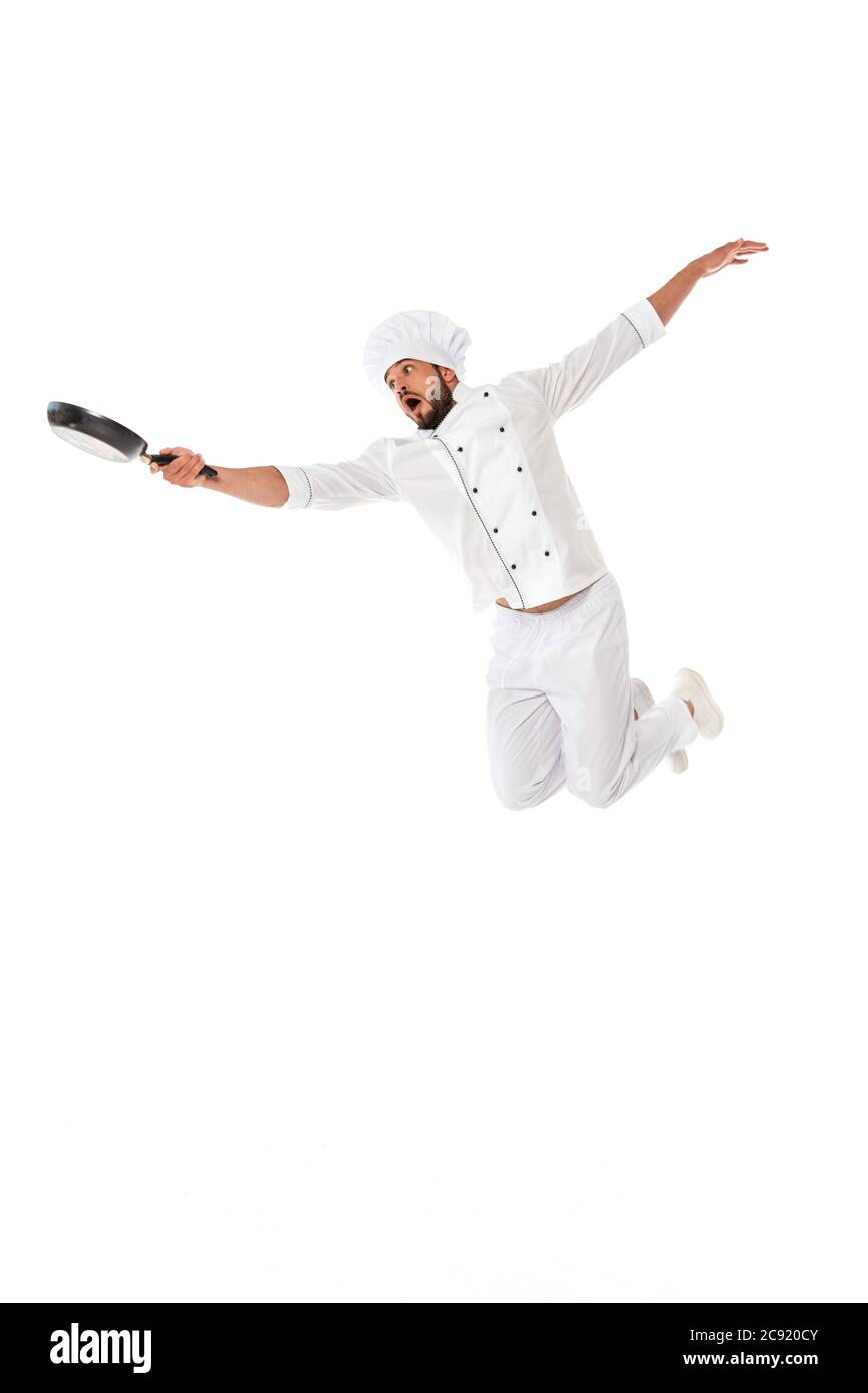 Excited chef holding frying pan while jumping isolated on white Stock ...