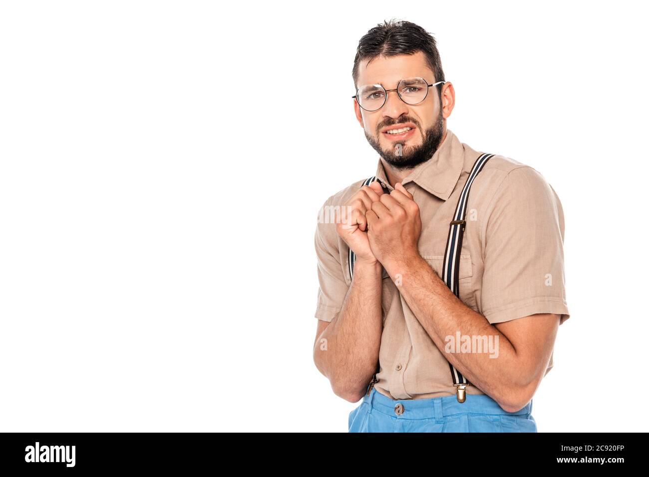 Scared nerd in suspenders and eyeglasses looking at camera isolated on ...