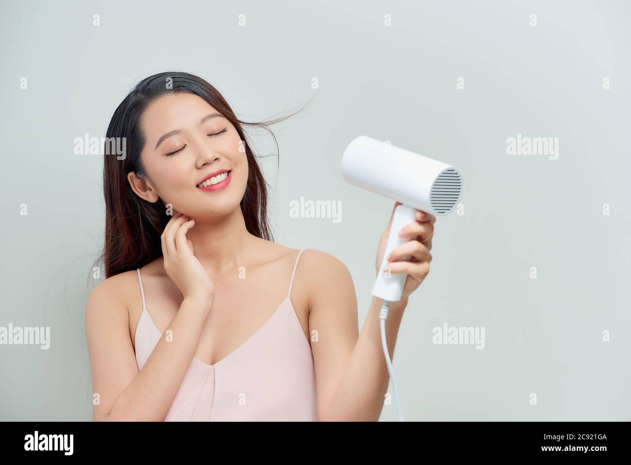 Young female drying her beautiful hair with hairdryer Stock Photo - Alamy