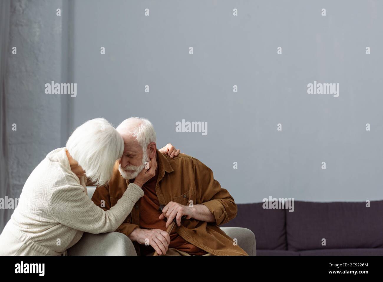 senior woman touching face and hugging husband sick on dementia Stock ...