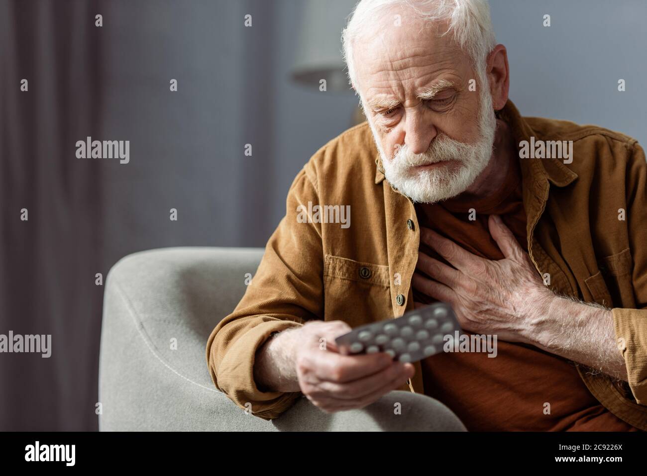 Old man holding chest hi-res stock photography and images - Alamy