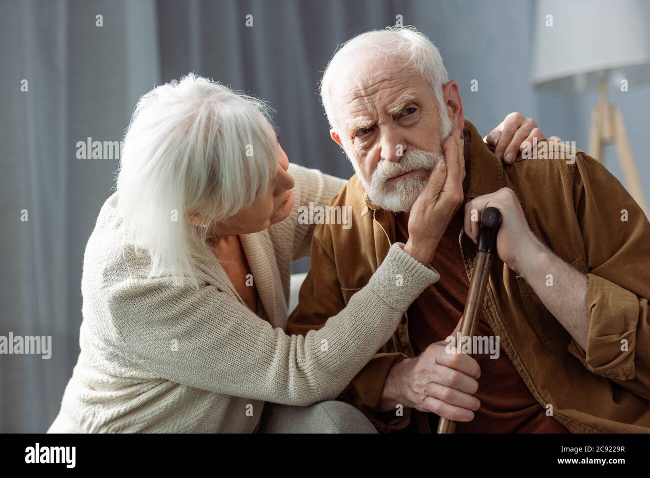senior woman touching face and hugging husband sick on dementia Stock ...