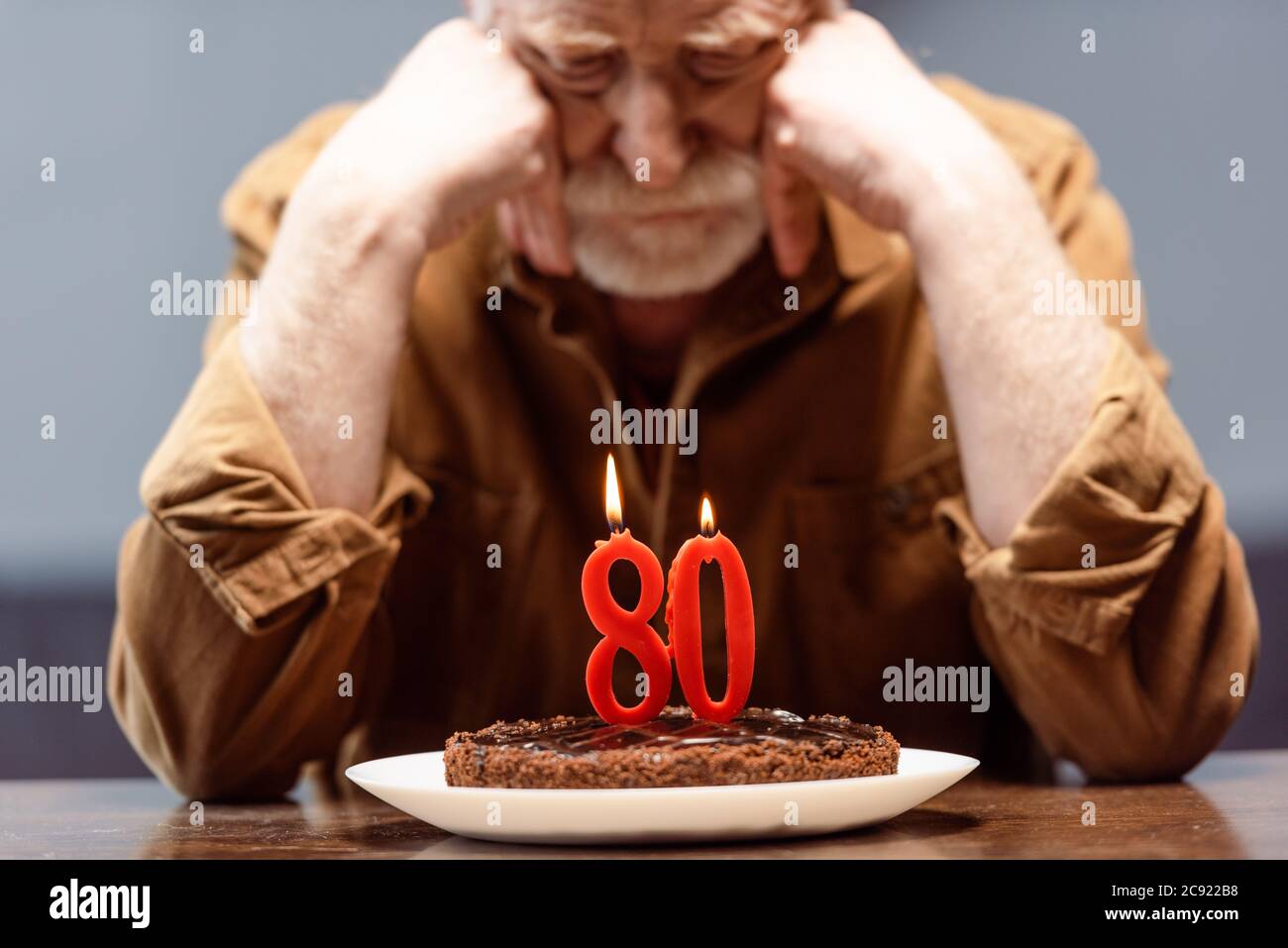 selective focus of lonely senior man leaning on hands while looking at ...