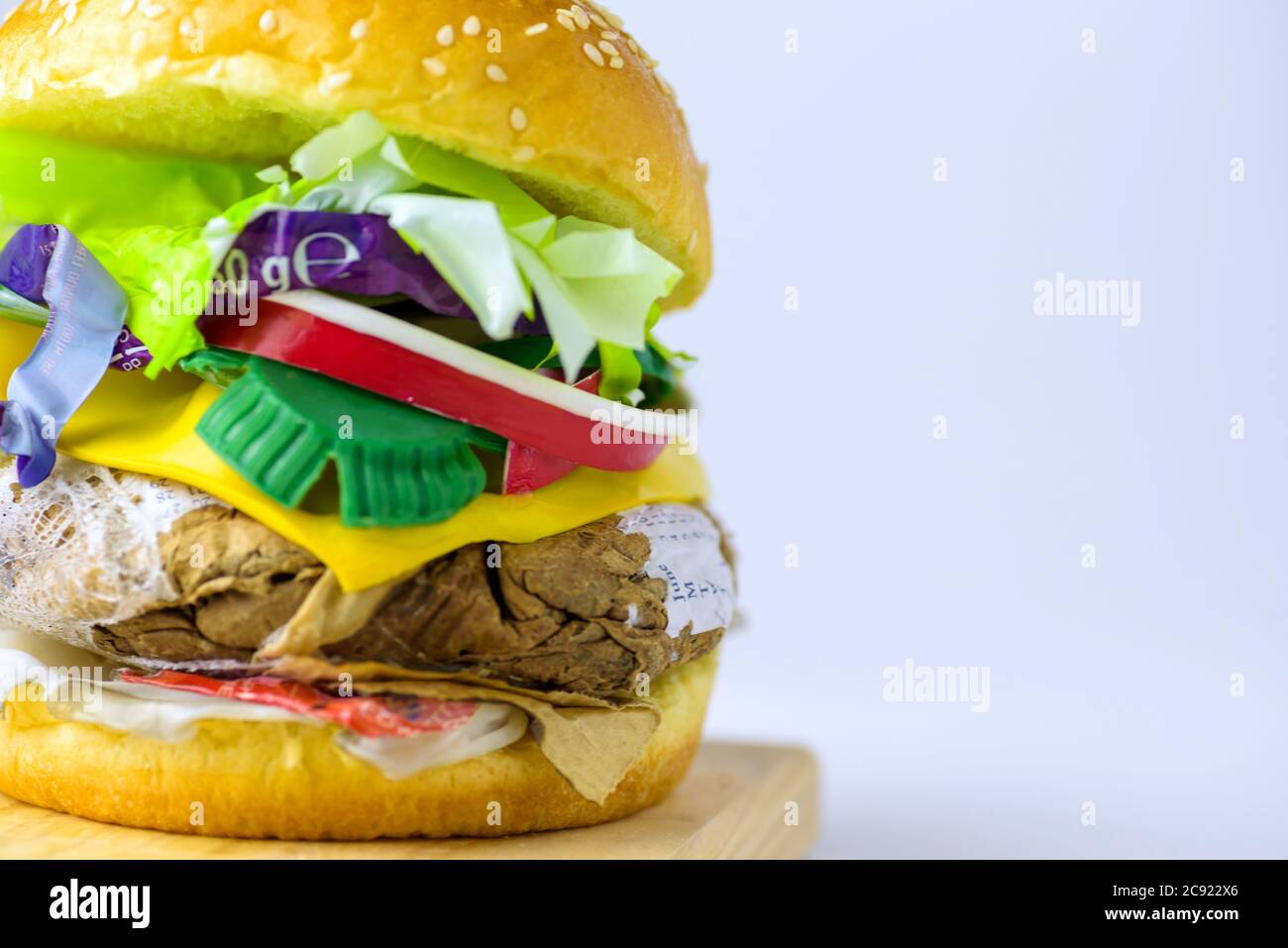 Burger filled with plastic waste and paper cardboard. Recycled waste in ...