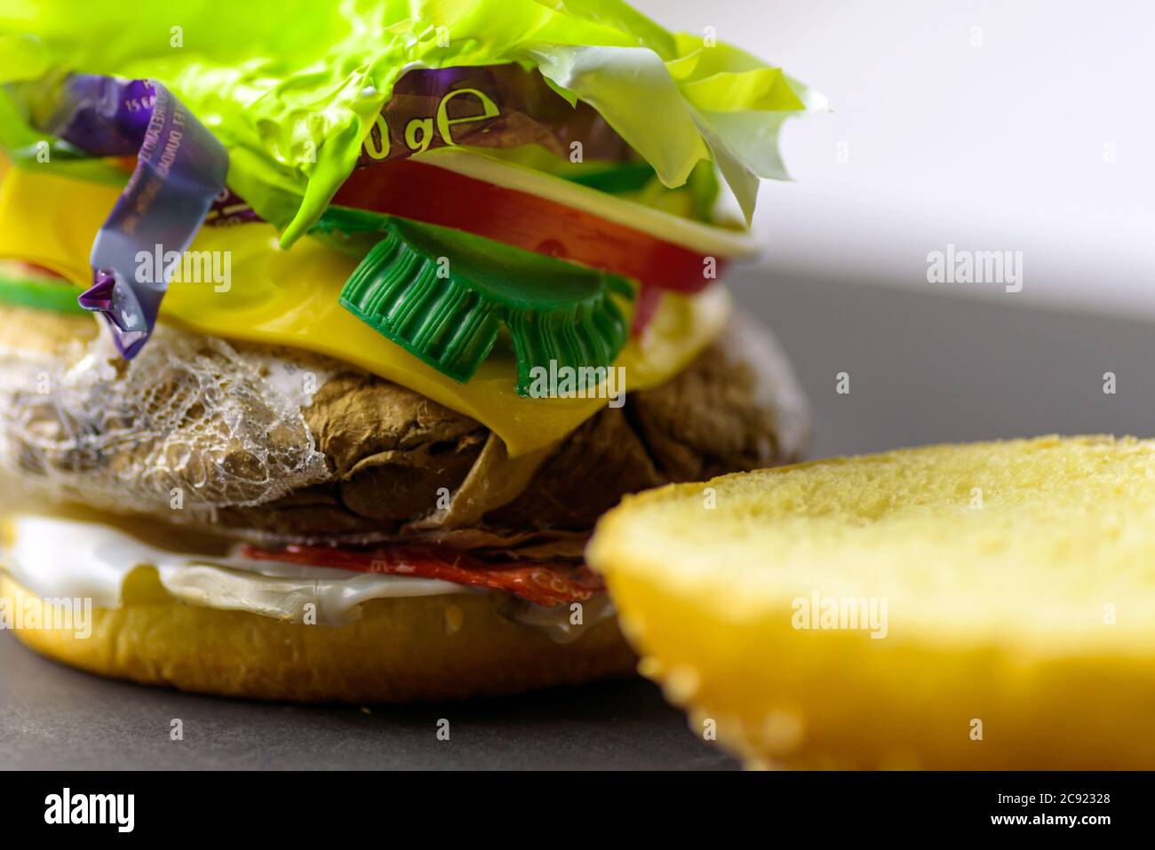 Burger filled with plastic waste and paper cardboard. Recycled waste in ...