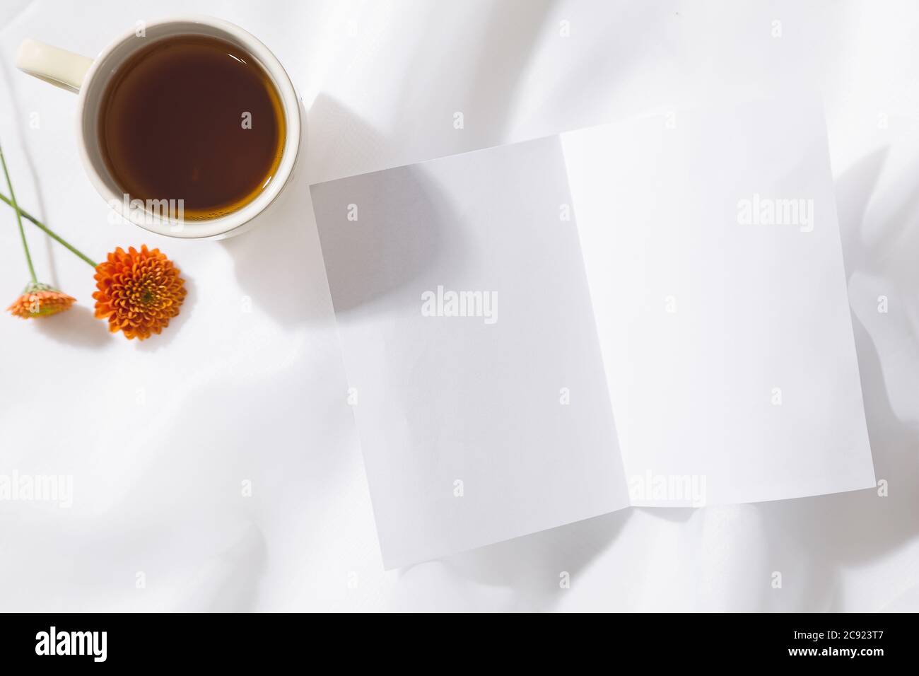 Top view of voile fabric background with a mug of tea, two orange ...