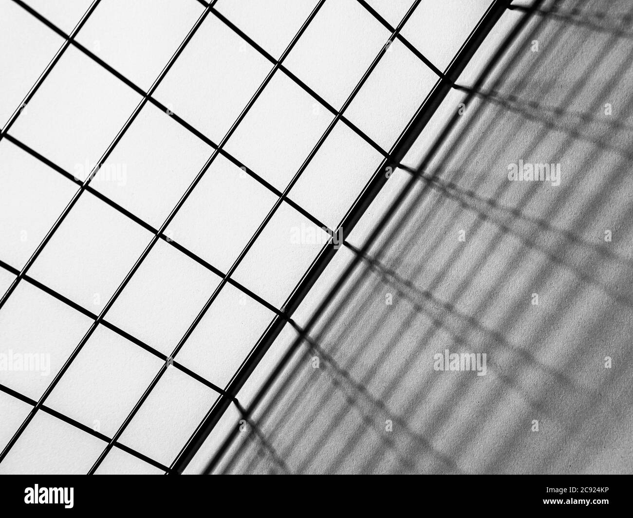 Black and white top view of a metal grid casting shadows Stock Photo ...