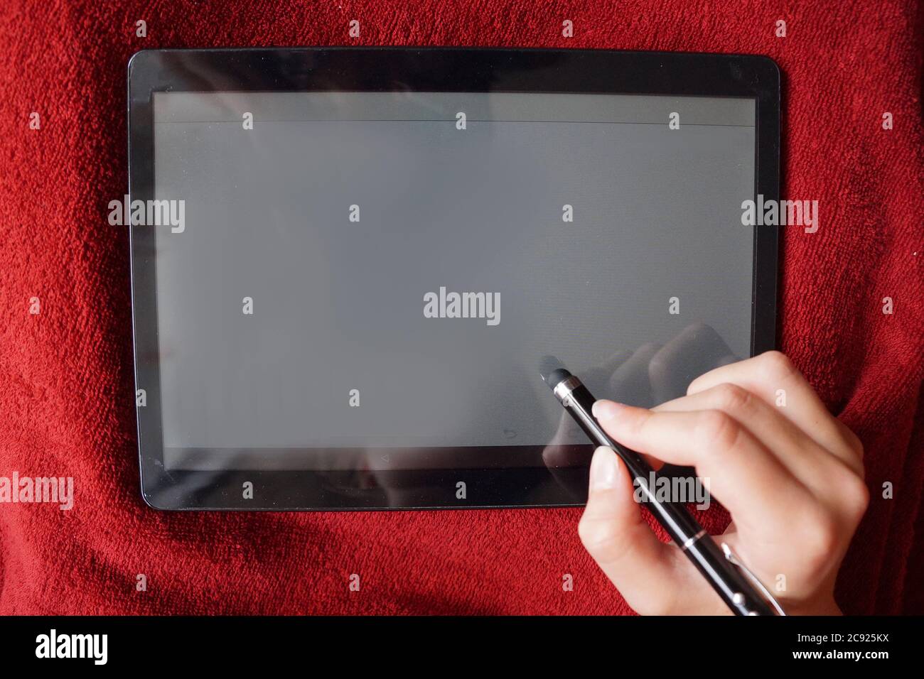 hand writes with a stylus on the white screen of the tablet, mock up ...