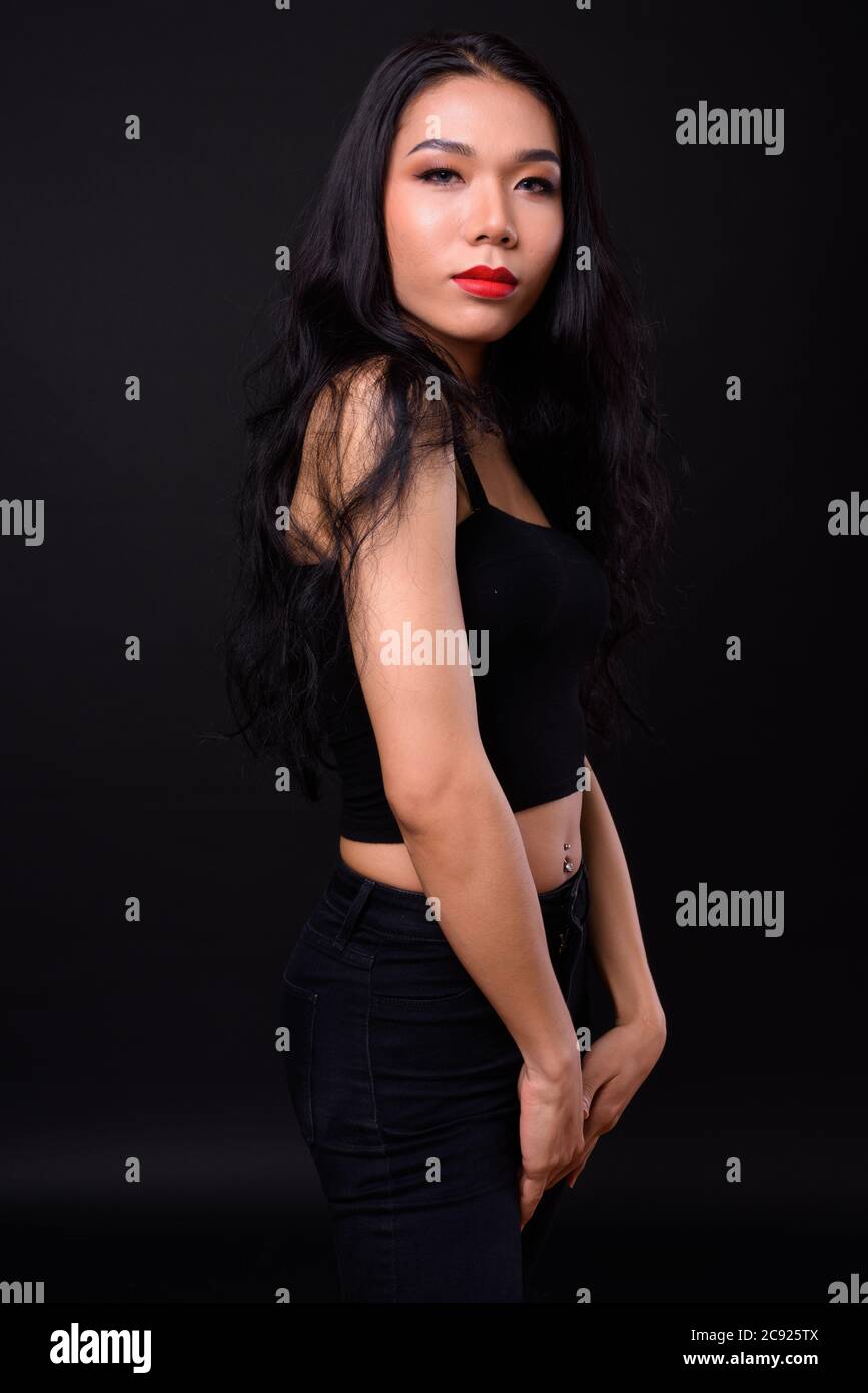 Young beautiful Asian transgender woman against black background Stock ...