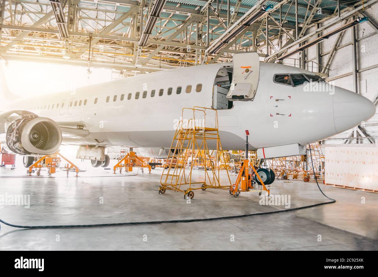 Airliner aircraft in a hangar with an open gate to the service Stock ...