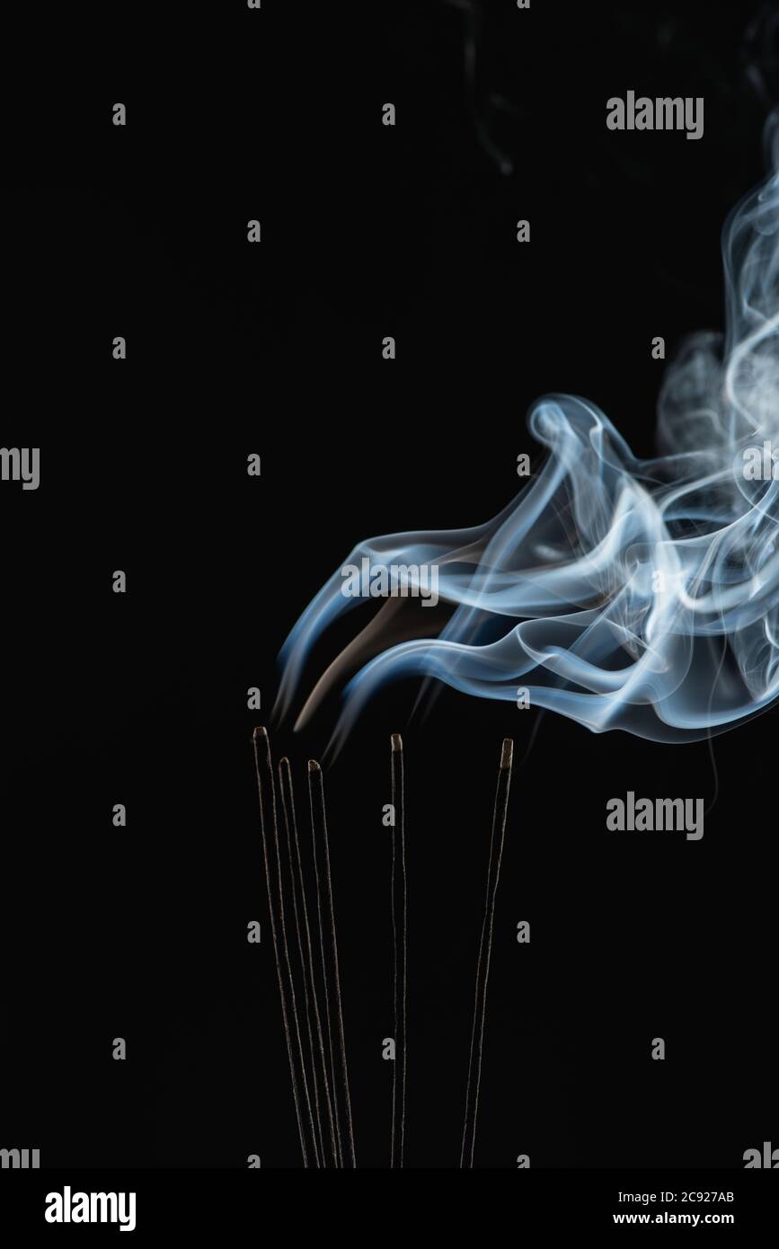 burning aroma sticks with smoke on black background Stock Photo - Alamy