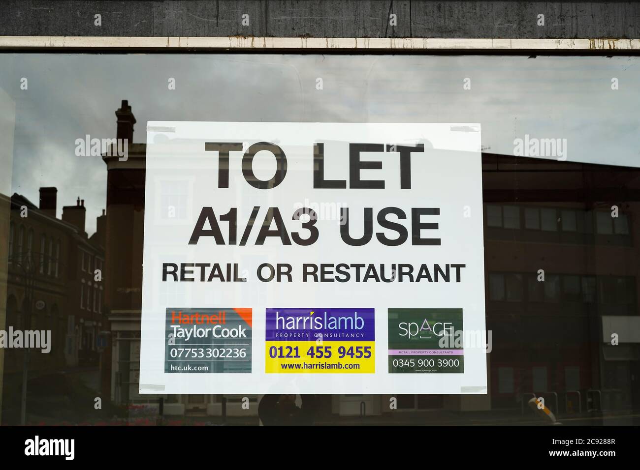 Close up window of another empty shop, retail unit displaying 'To Let ...