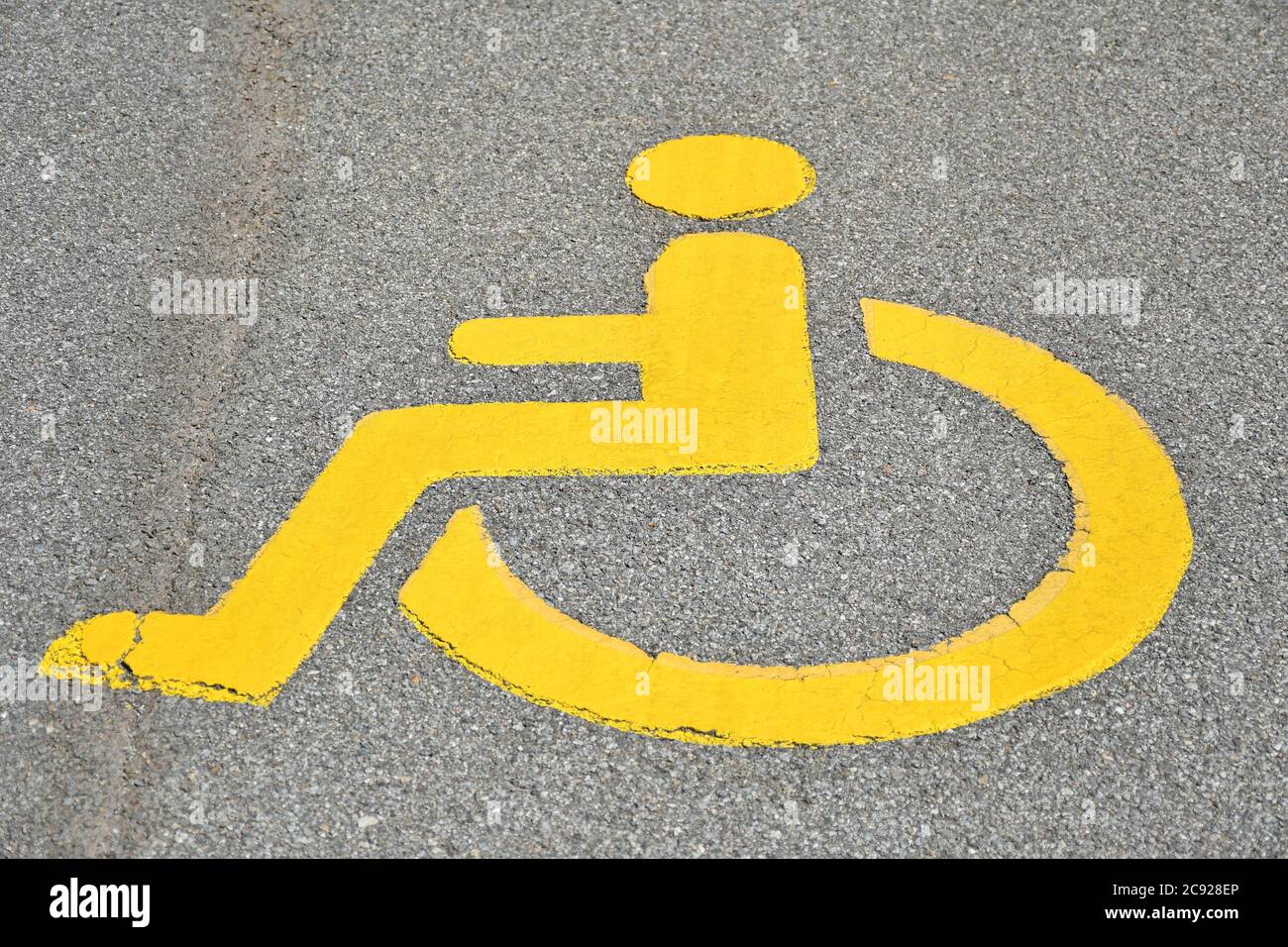 Yellow disabled sign on the asphalt of the street Stock Photo - Alamy